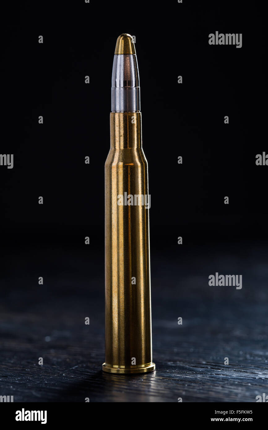 Large-caliber cartridge on a dark background Stock Photo - Alamy