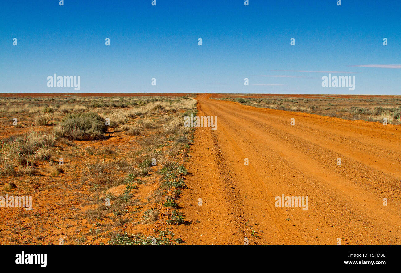 Long red dirt road in Australian outback stretching across arid ...