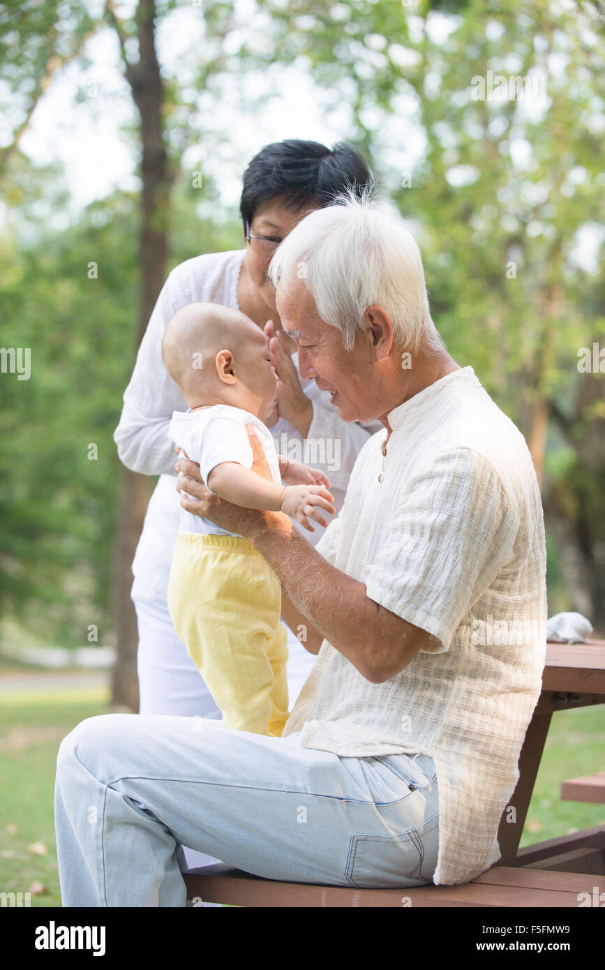 chinese grandfather and grandmother playing with baby grandson at ...
