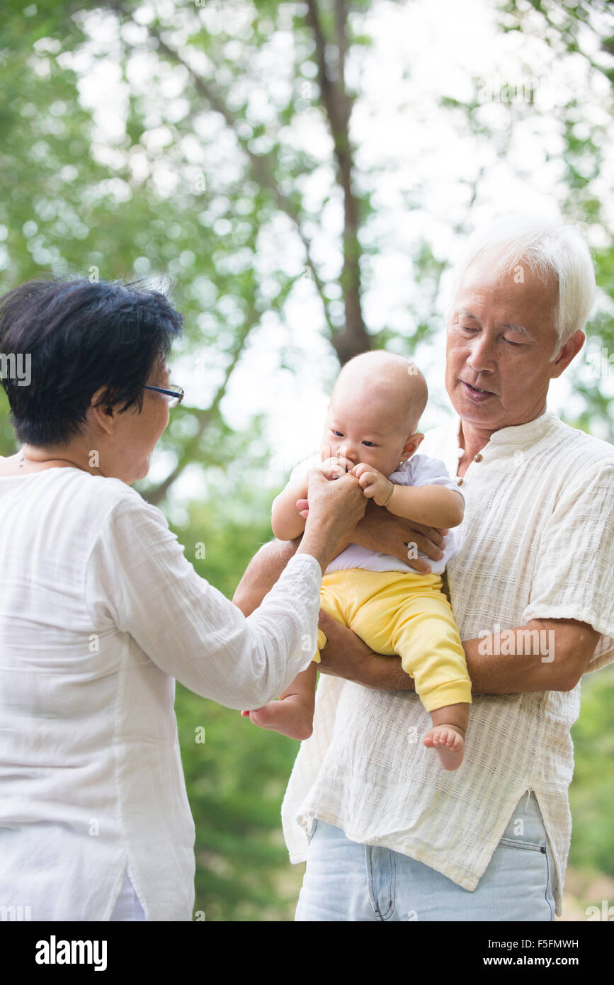 chinese grandfather and grandmother playing with baby grandson at ...