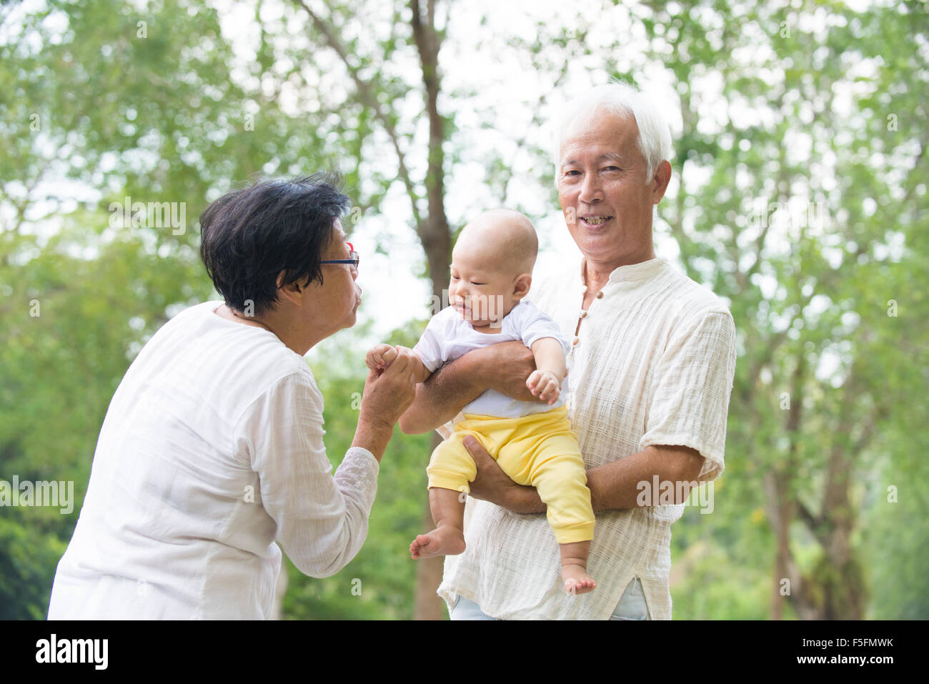 chinese grandfather and grandmother playing with baby grandson at ...