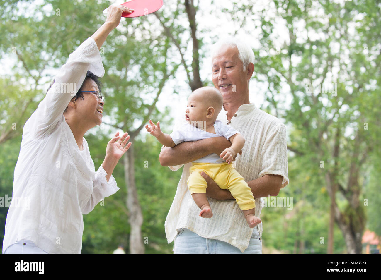 chinese grandfather and grandmother playing with baby grandson at ...