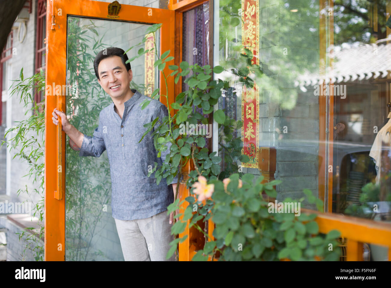 Male shopkeeper opening the door of store Stock Photo - Alamy