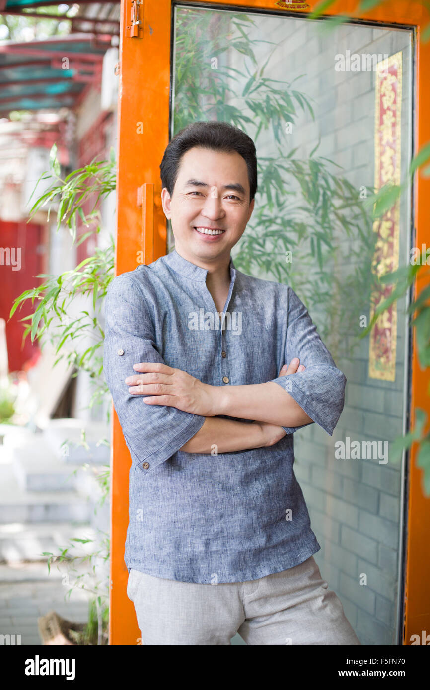 Male shopkeeper standing in doorway of his store Stock Photo - Alamy
