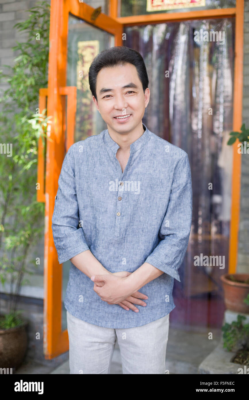 Male shopkeeper standing in doorway of his store Stock Photo - Alamy