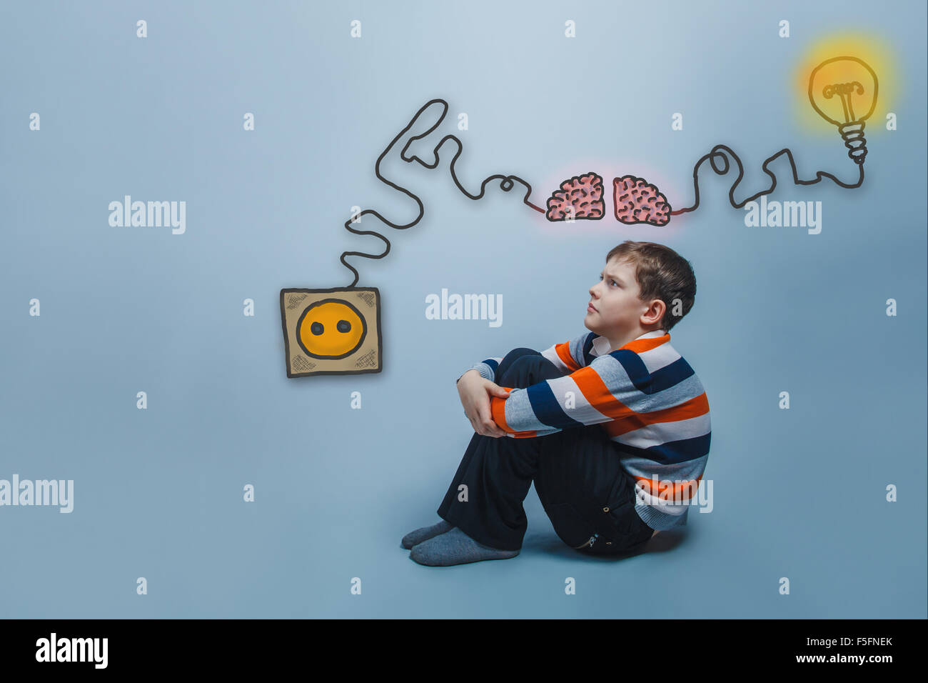 boy sitting on the floor hugging his arms legs and looking up ch Stock ...