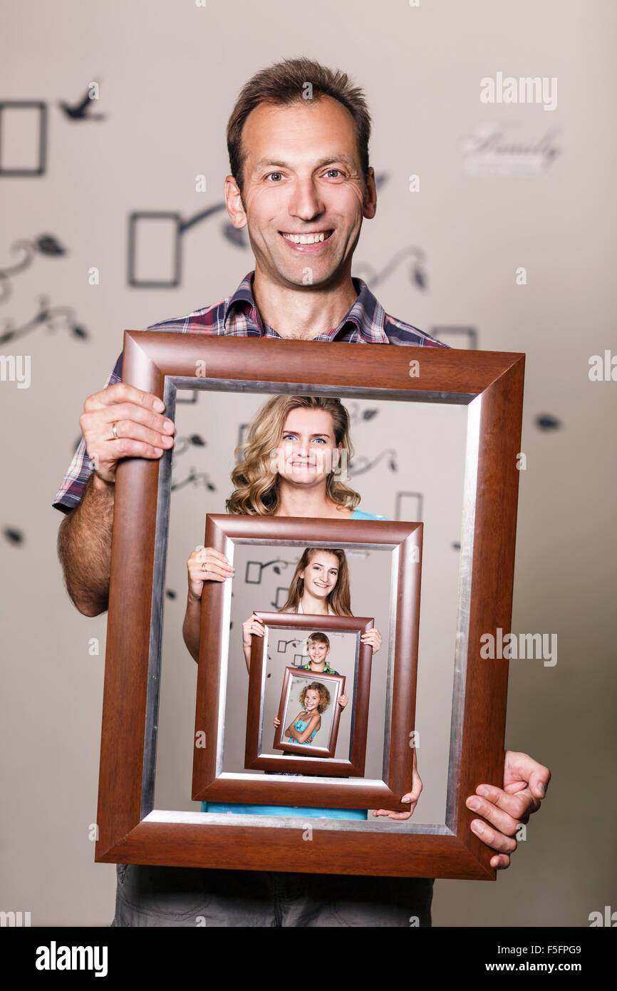 Happy father holding portrait with his family Stock Photo - Alamy