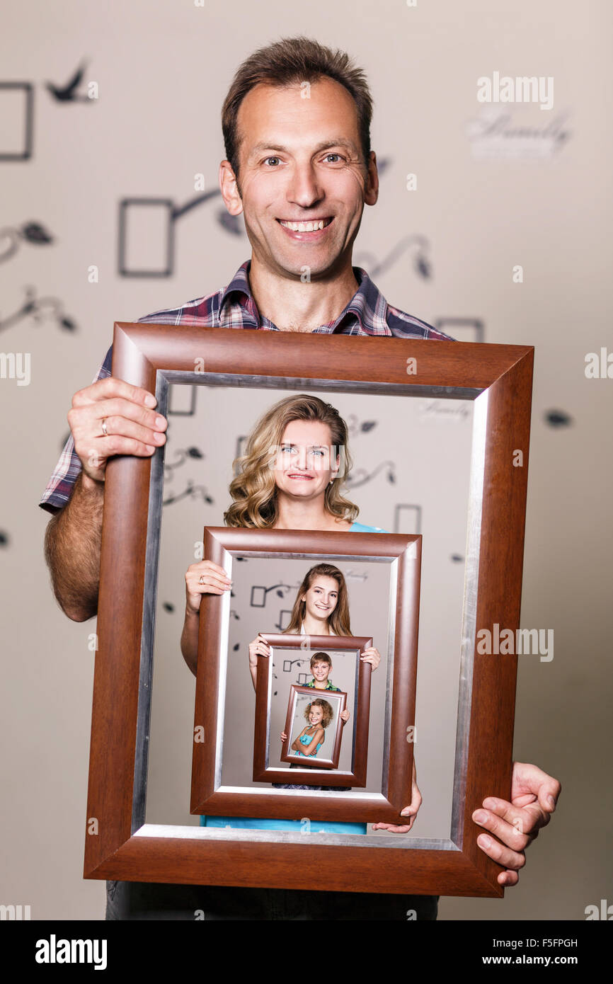 Happy father holding portrait with his family Stock Photo - Alamy