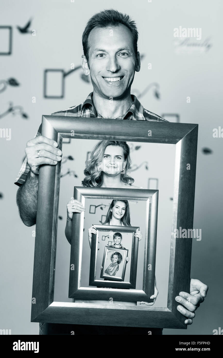 Happy father holding portrait with his family Stock Photo - Alamy