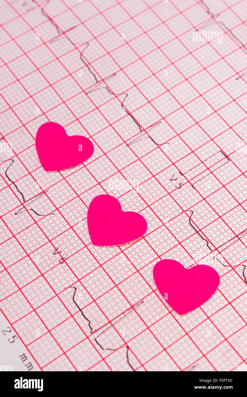 Hearts of paper lying on electrocardiogram graph, ecg heart rhythm ...