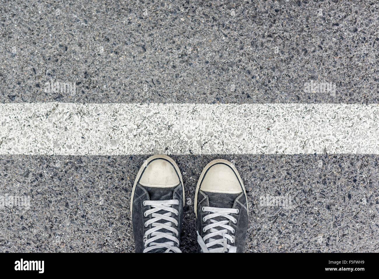 Man standing at the border line on urban pavement, top view of young ...