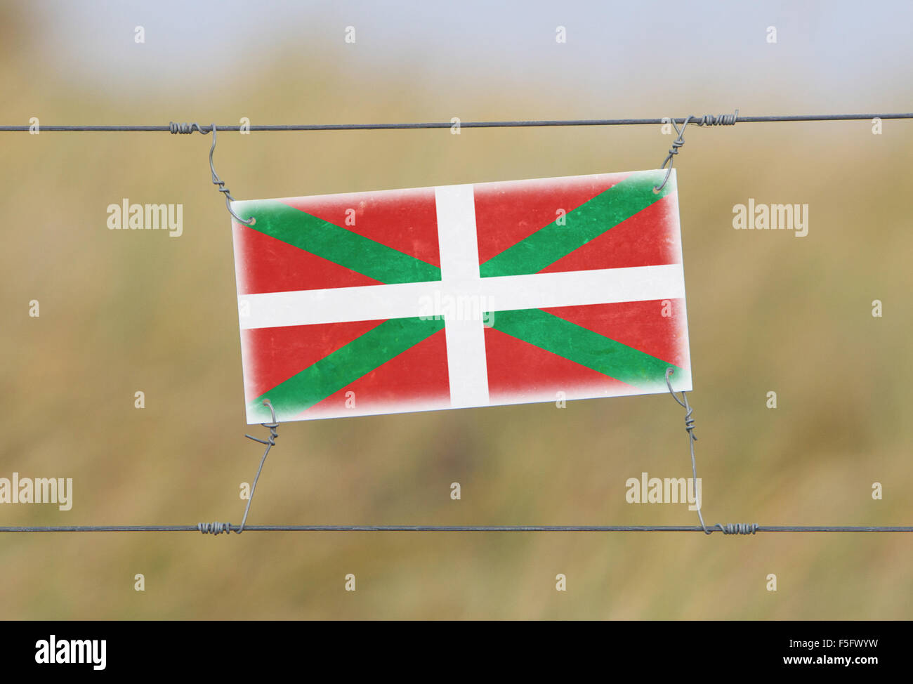 Border fence - Old plastic sign with a flag - Basque Country Stock ...