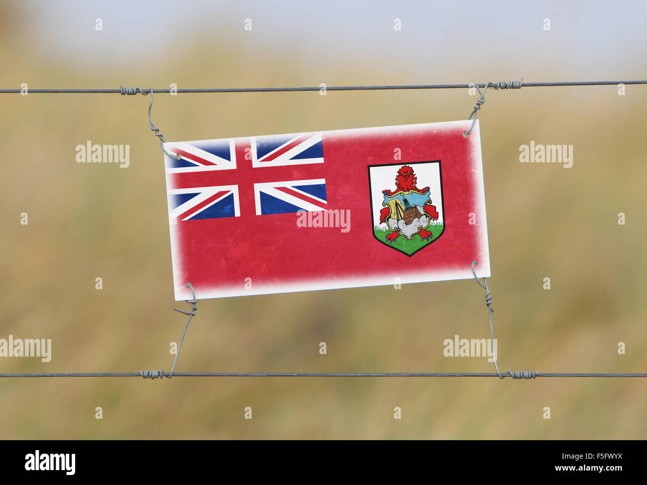 Border fence - Old plastic sign with a flag - Bermuda Stock Photo - Alamy