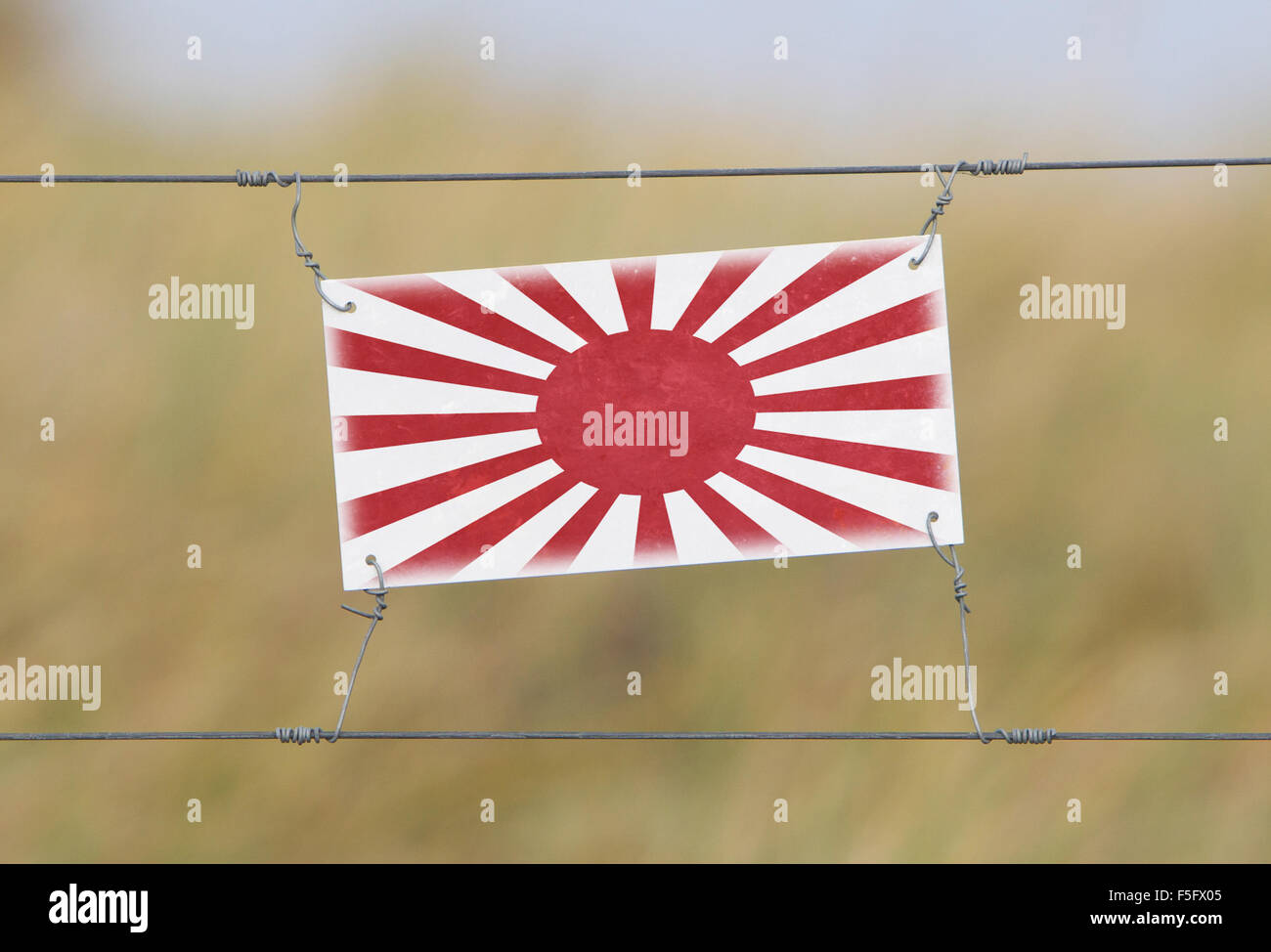 Border fence - Old plastic sign with a flag - Japan Stock Photo - Alamy