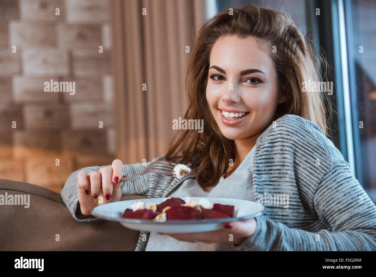 Beautiful smiling girl eating delicious dish Stock Photo - Alamy