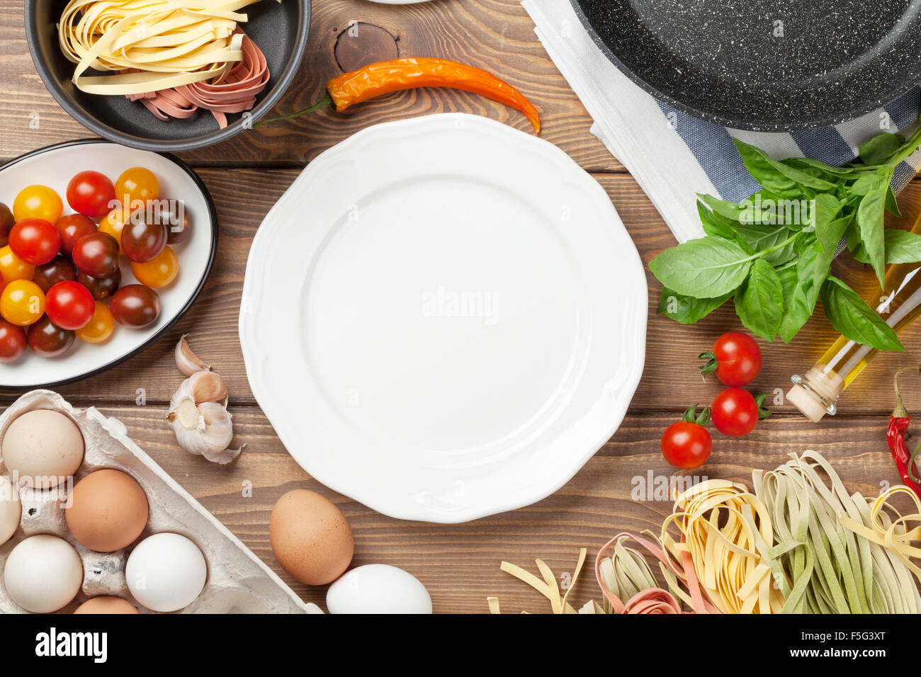 Pasta cooking ingredients and utensils on wooden table. Top view with ...