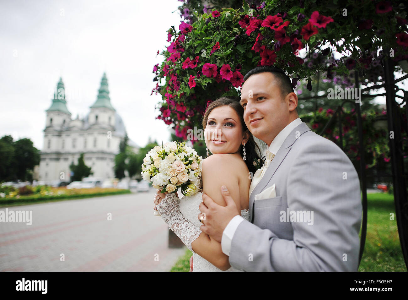 Happy married hugging on background church Stock Photo - Alamy