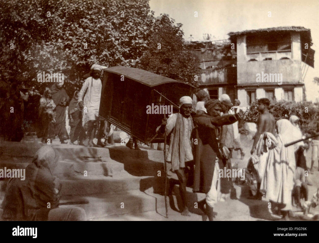 Group of Indians carrying a person inside a small carriage without ...
