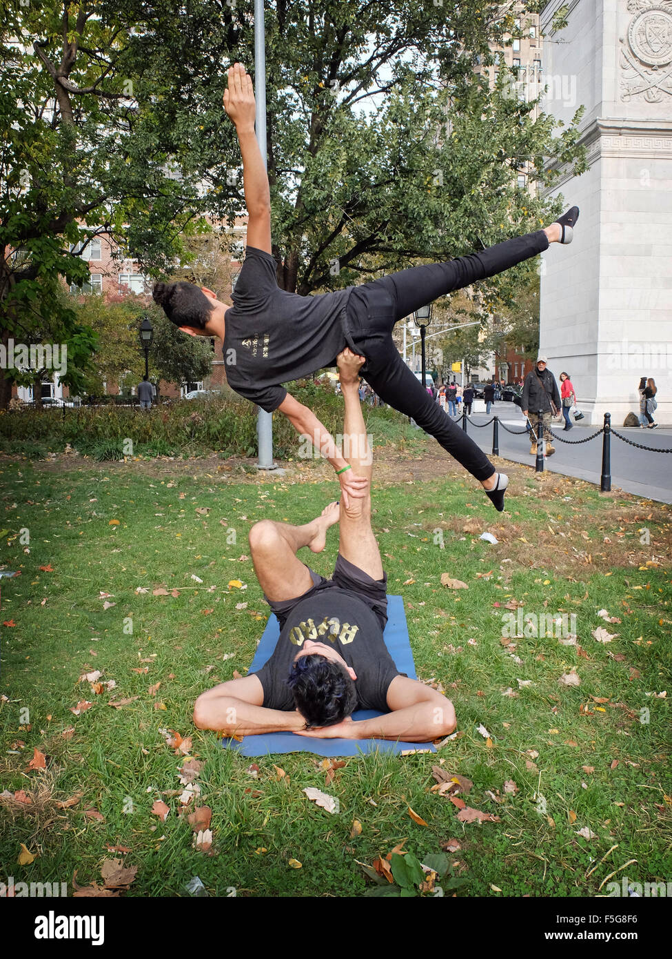 Two athletic fit men do acro yoga exercises in Washington Square Park ...