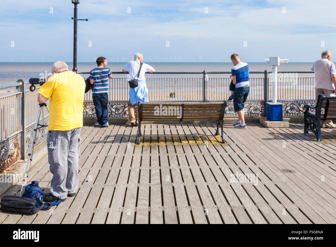 People viewing the sea and the wind farm on the horizon. The seaside ...