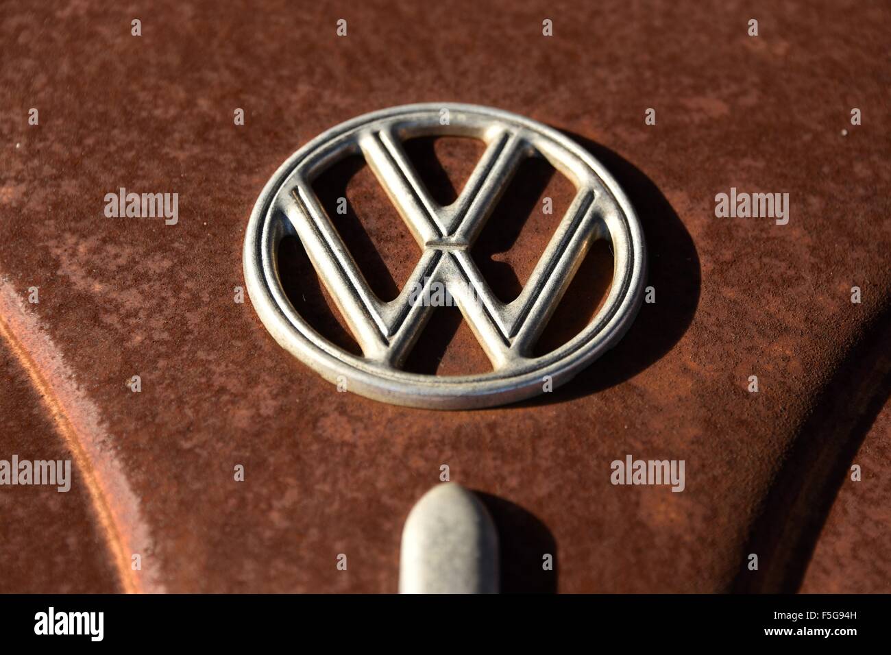 The Volkswagen logo is displayed on the hood of a rusty VW Beetle in ...