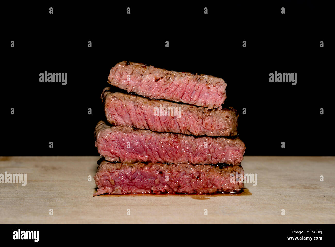 Beef steak tower on chopping board with black background Stock Photo ...