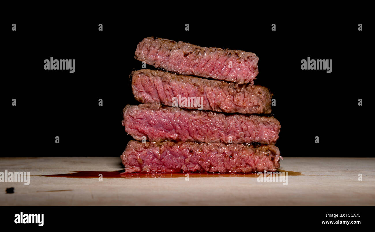 Beef steak tower on chopping board with black background Stock Photo ...