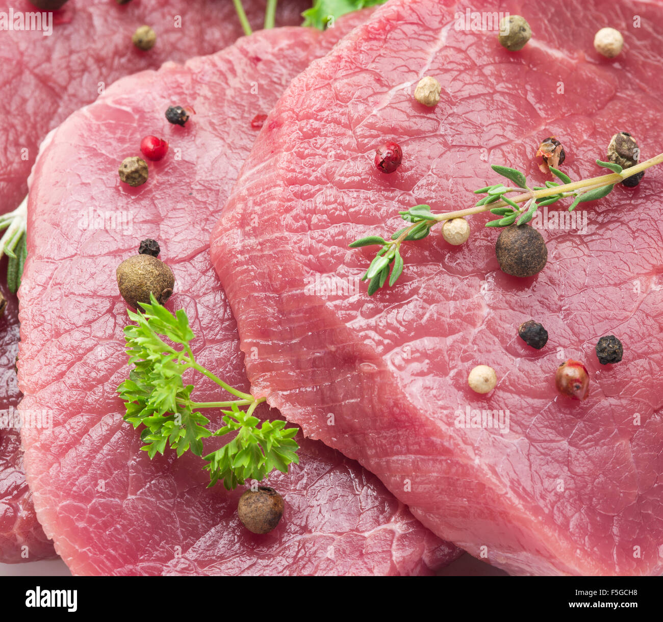 Raw beef steaks with spices on a white background Stock Photo - Alamy