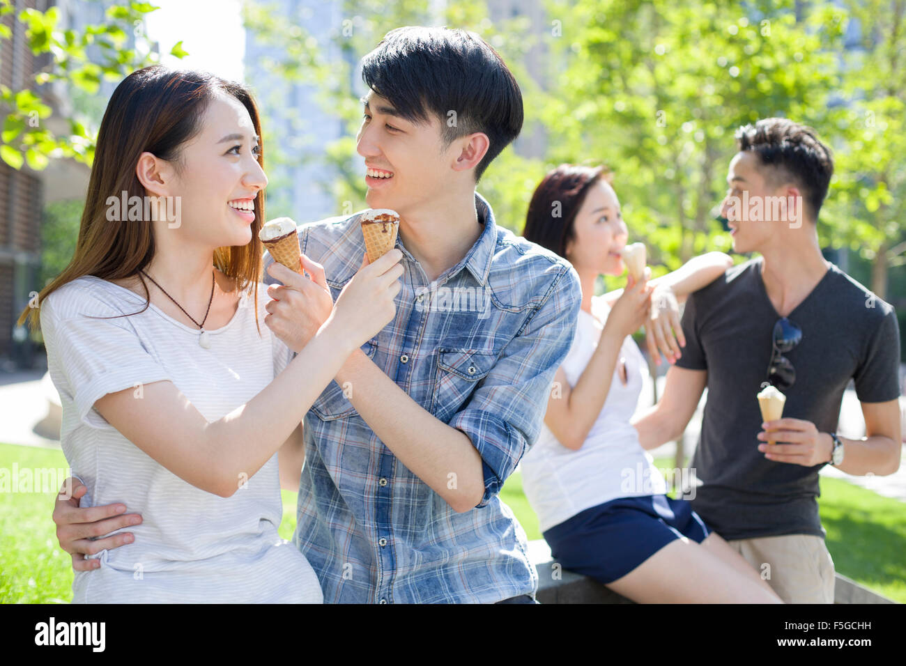 Happy young adults eating ice cream Stock Photo - Alamy