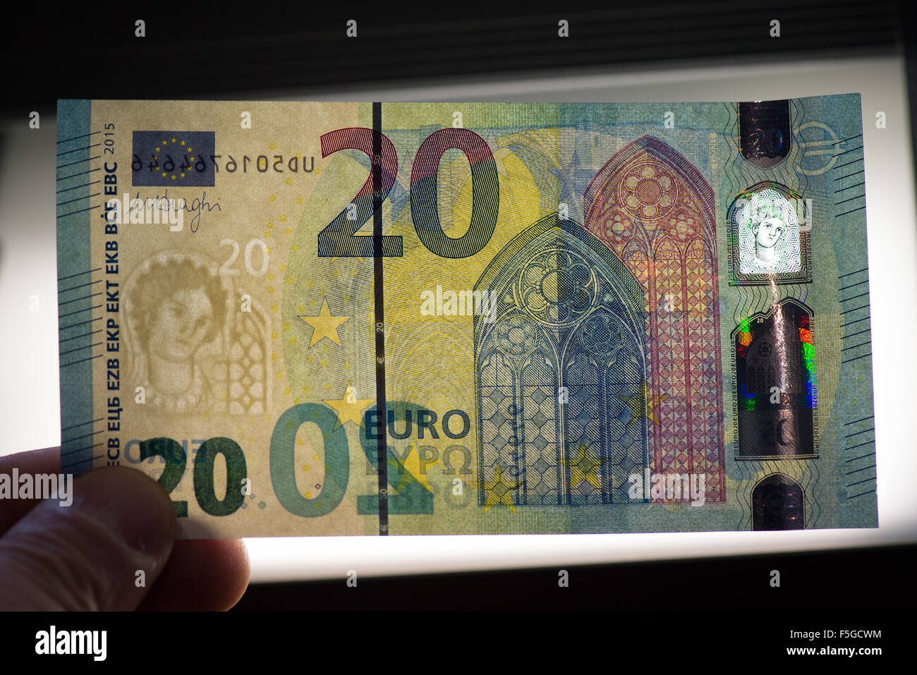 A Federal Bank employee holds up the new 20 euro note in Duesseldorf ...