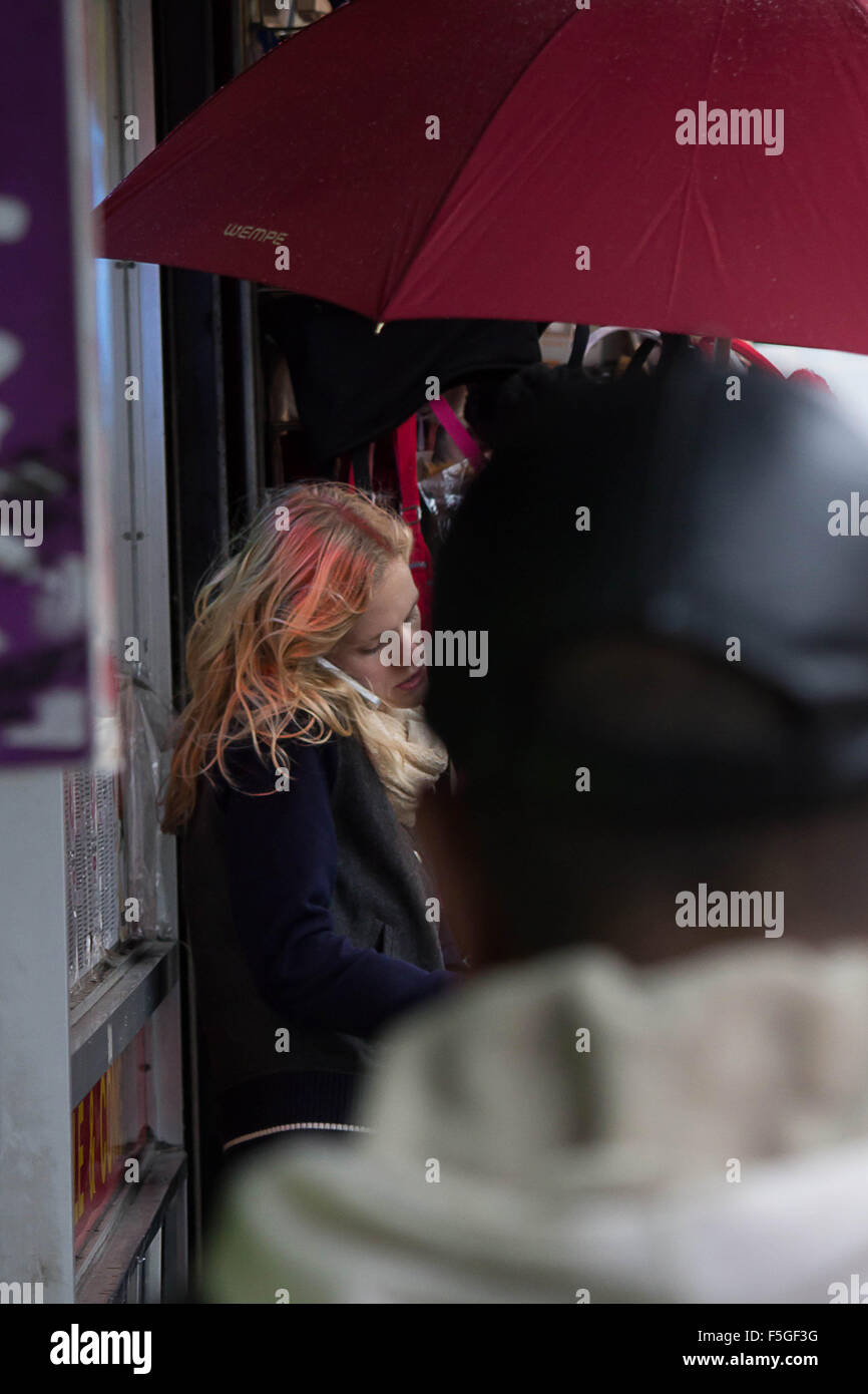 Hiding from the rain- a young lady takes shelter from the rain on Canal ...