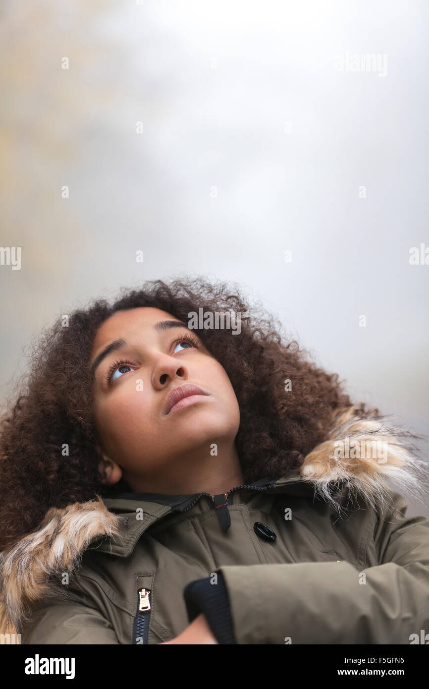 A beautiful thoughtful sad thinking mixed race African American girl or ...