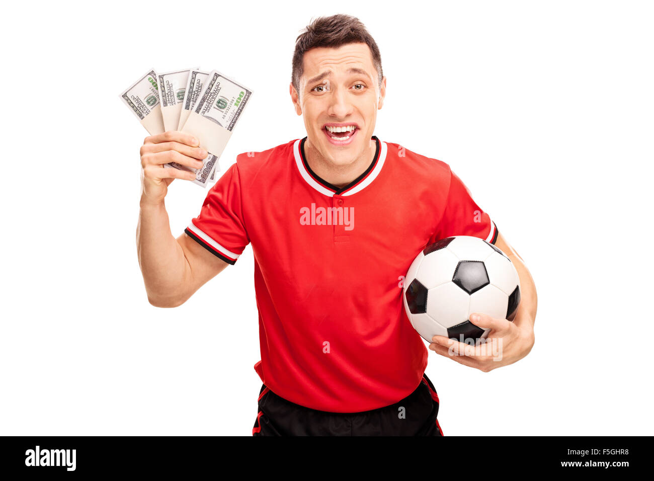 Happy football player holding a ball and a few stacks of money isolated ...
