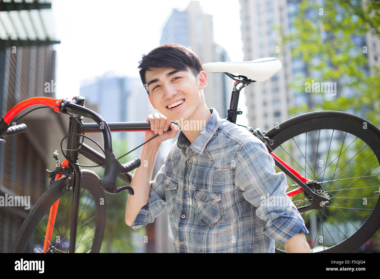 Young man carrying bicycle on shoulder Stock Photo - Alamy