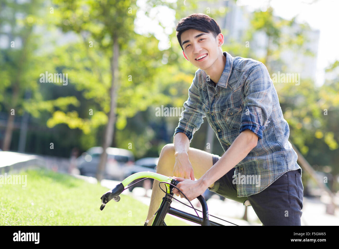 Happy young man riding bicycle Stock Photo - Alamy