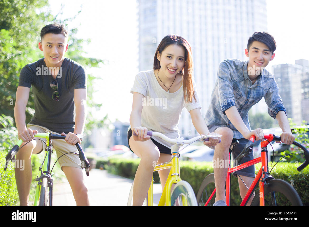Happy young adults riding bicycles Stock Photo - Alamy