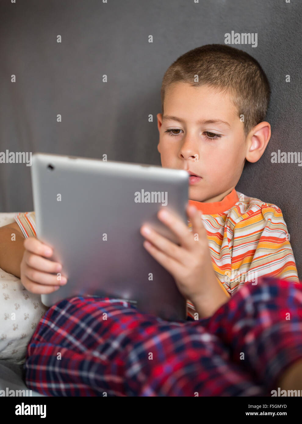 The boy using tablet, sitting in the bed Stock Photo - Alamy