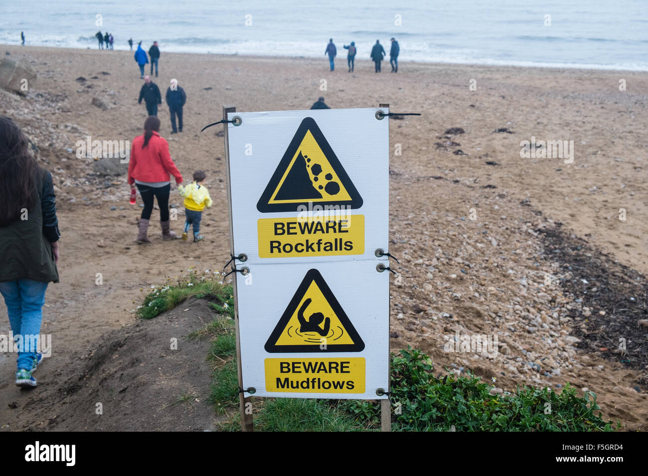 Sign rock fall danger.Hunting for fossils on a wind-swept and wet day ...