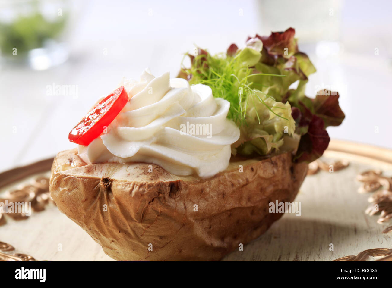 Baked potato topped with creamy spread Stock Photo - Alamy