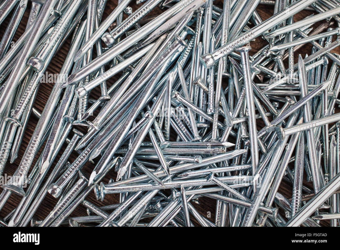 iron nails on wooden background Stock Photo - Alamy