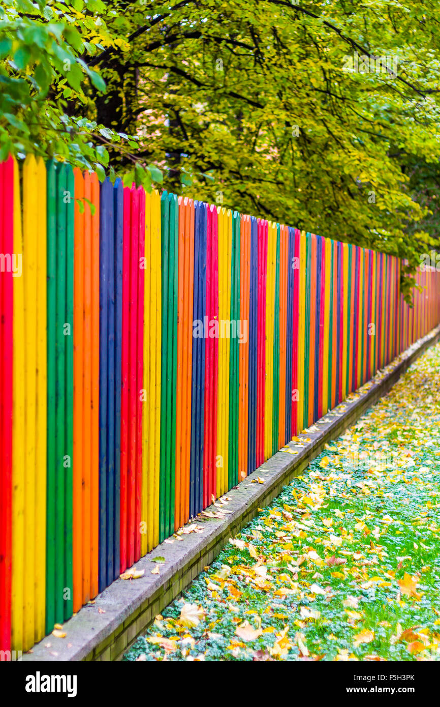 Multi colored rainbow wooden fence in autumn, garden background, soft ...