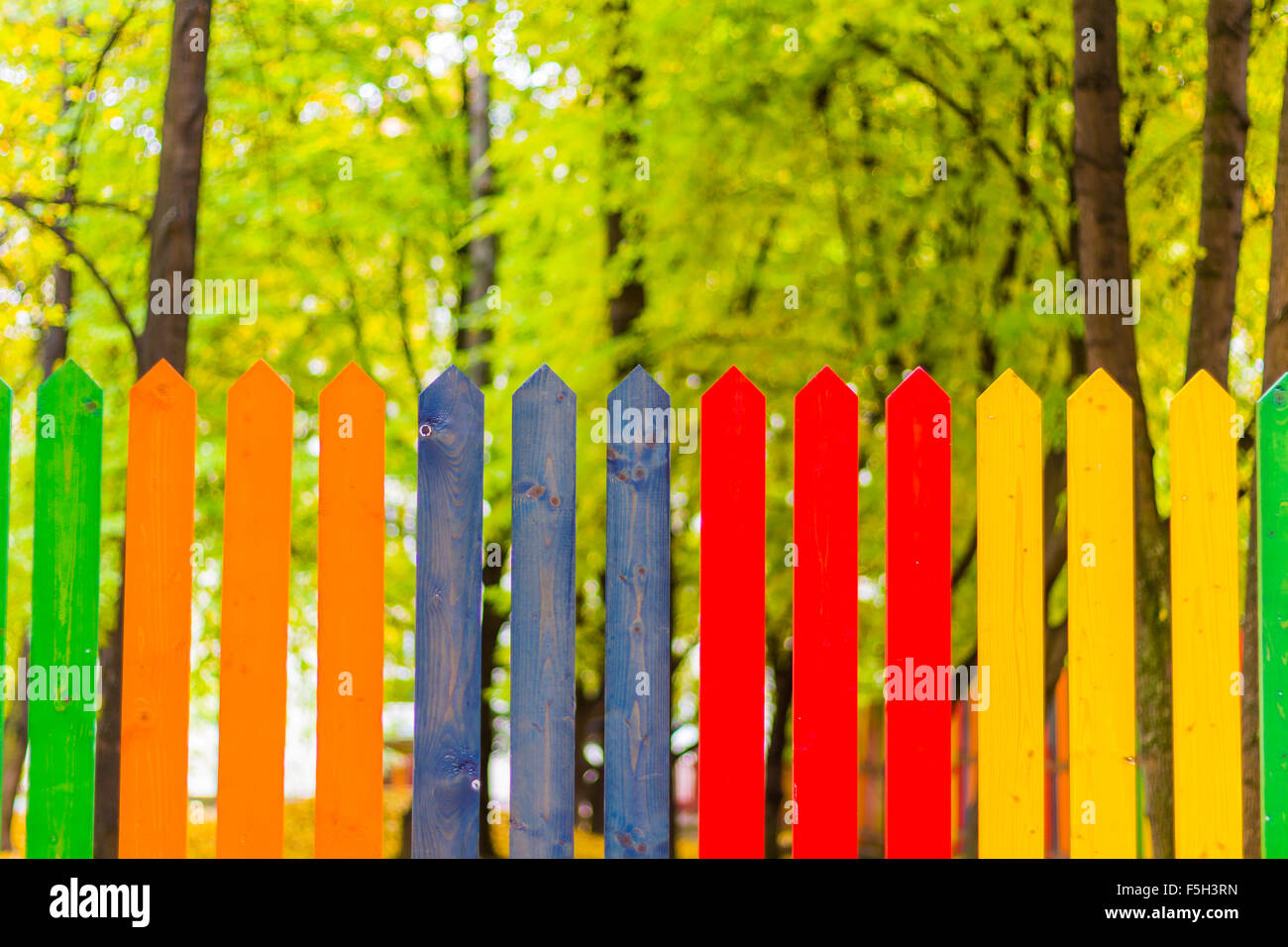 Multi colored rainbow wooden fence in autumn, garden background, soft ...