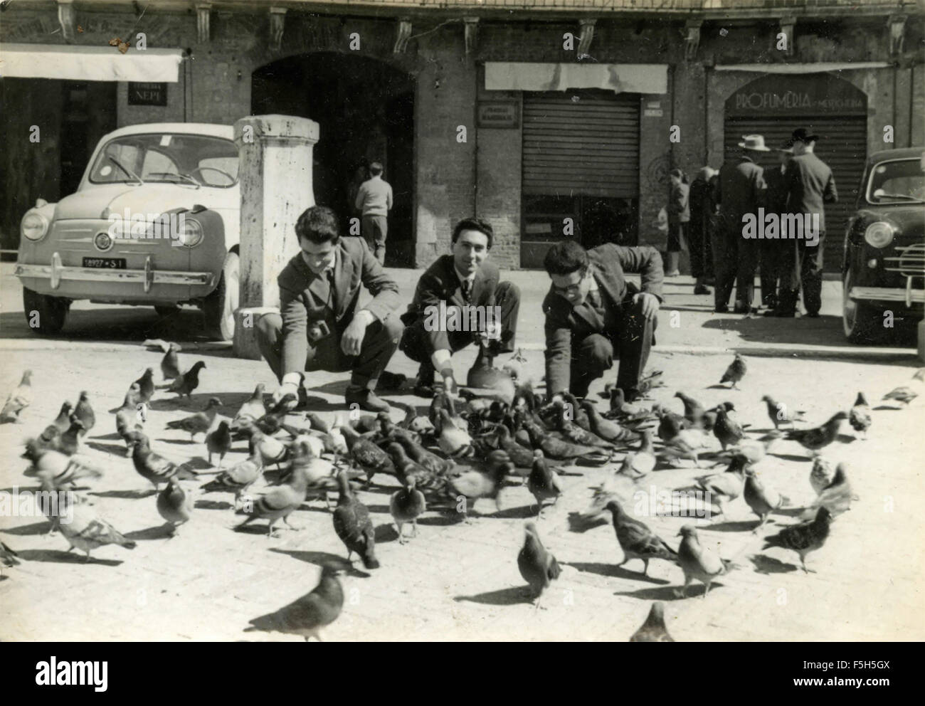 Three friends feeding the pigeons, Italy Stock Photo - Alamy