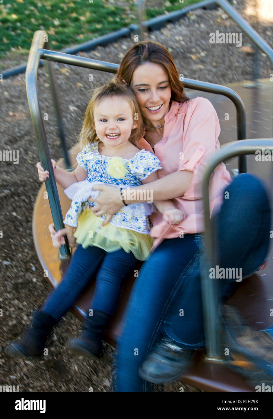 Beautiful mother and cute young daughter girl playing outside on merry ...