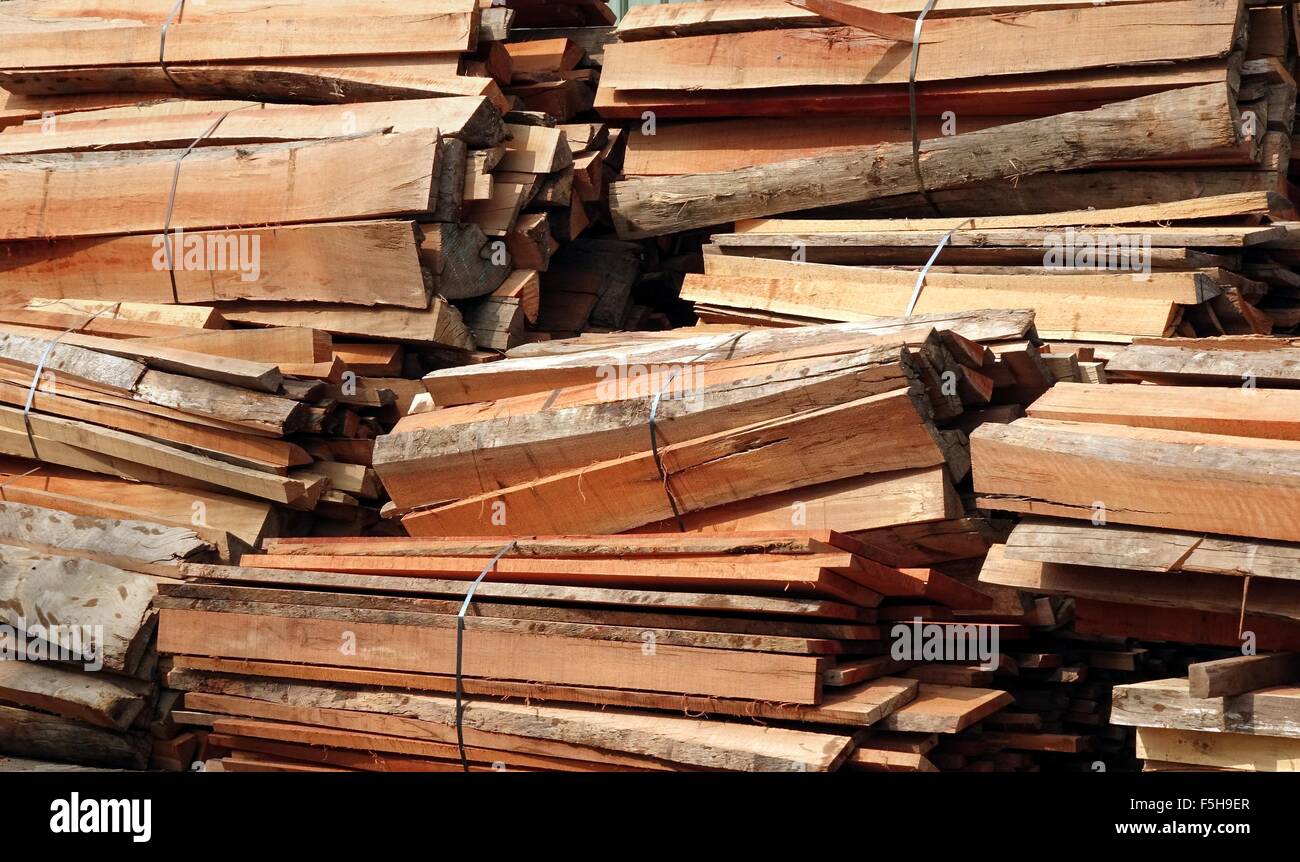 Large piles of hardwood lumber and planks are tied together with steel ...