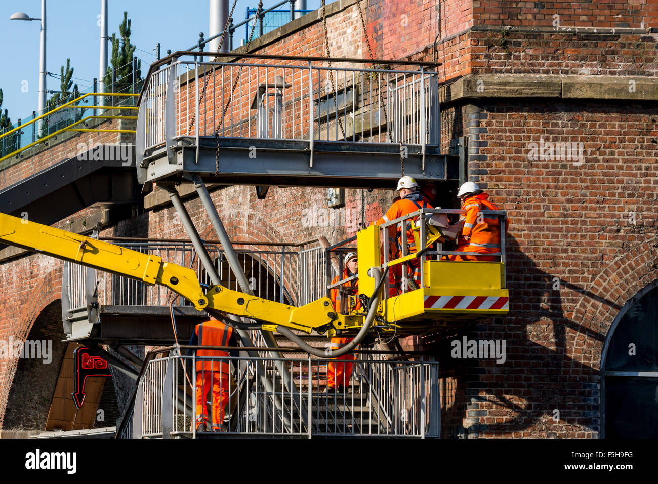 Workman on an access platform dismantling an old staircase at the ...