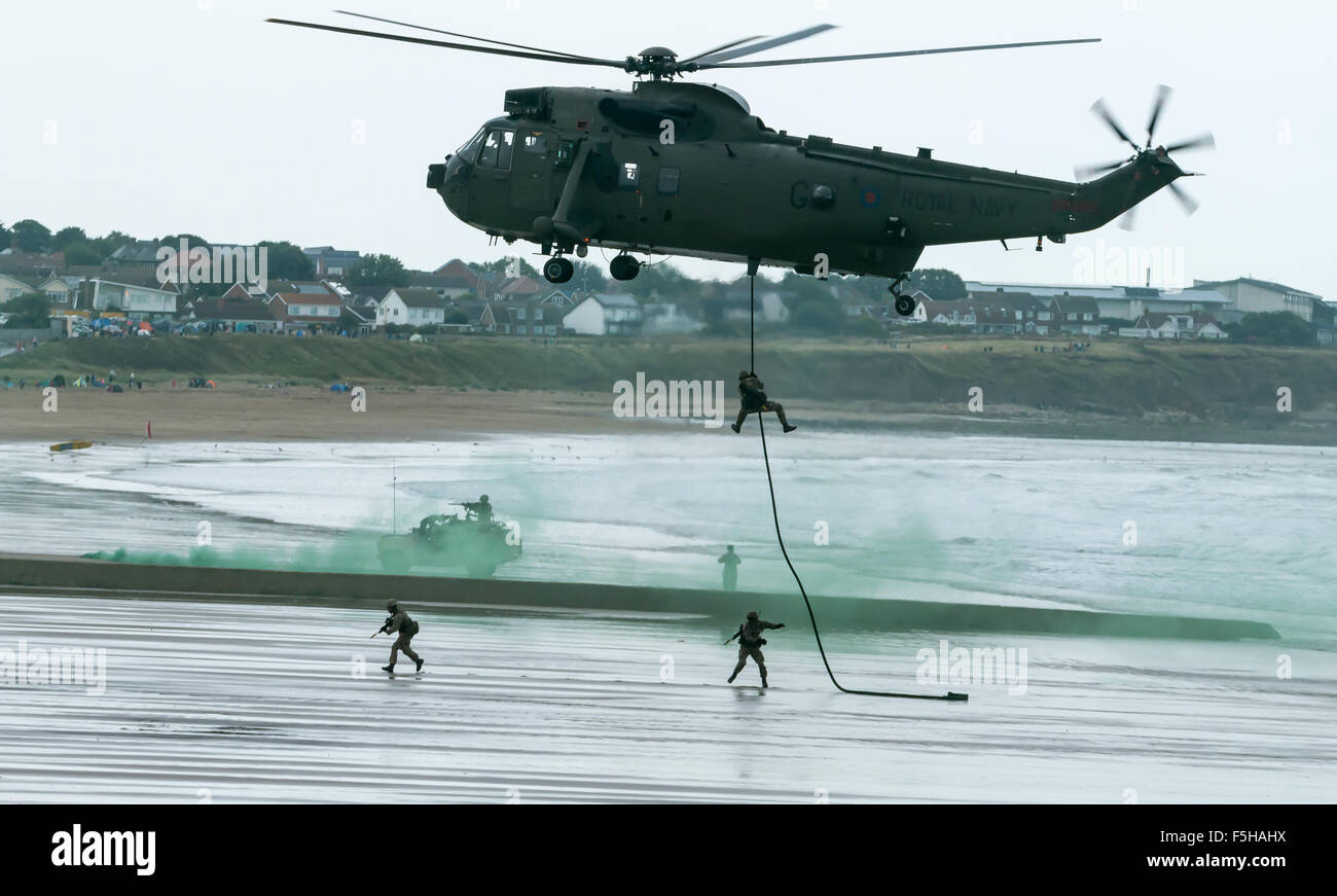 British Royal Marine Commandos fast-line from a helicopter perform a ...