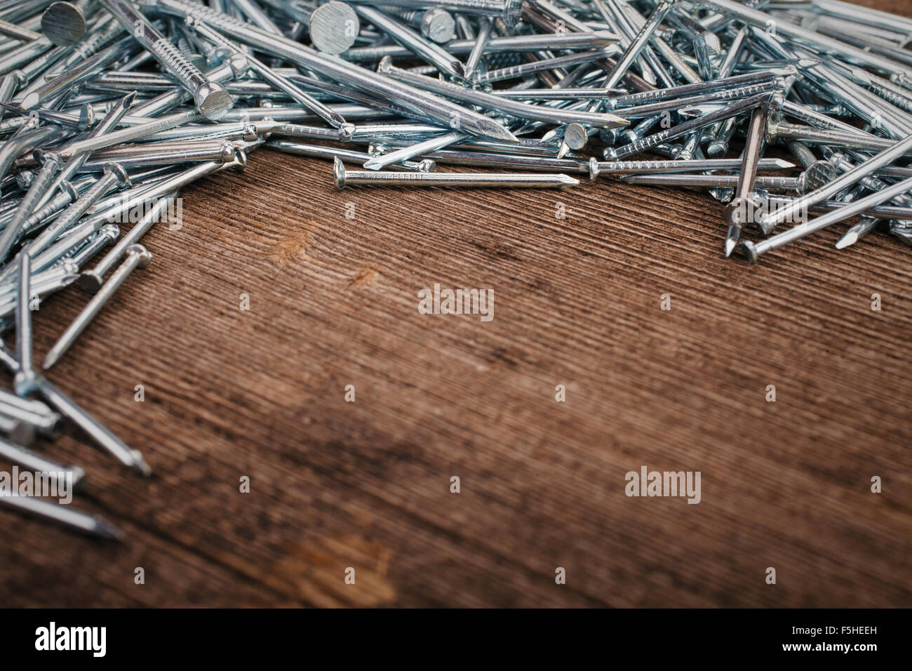 iron nails on wooden background Stock Photo - Alamy