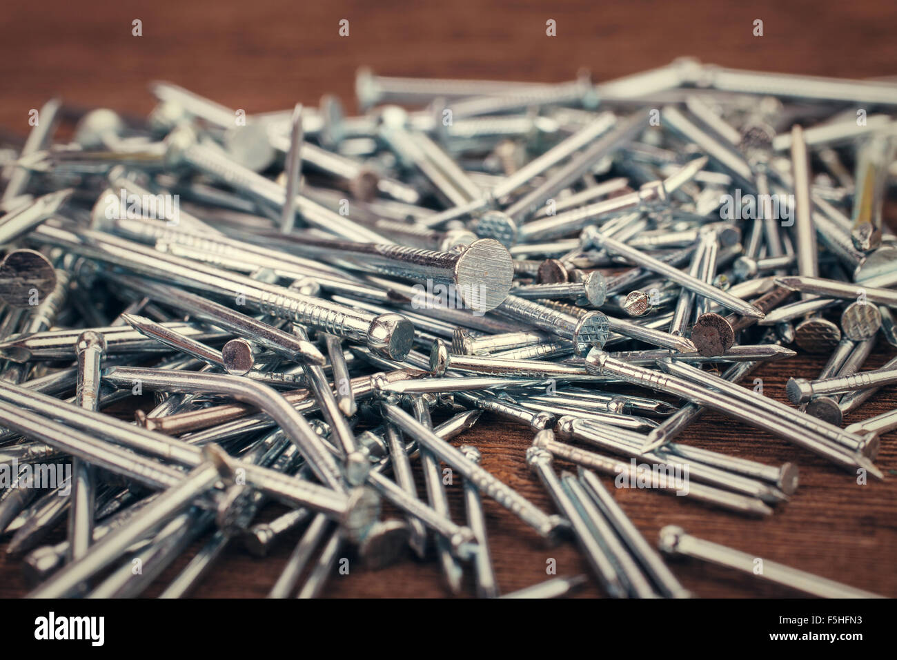 iron nails on wooden background Stock Photo - Alamy