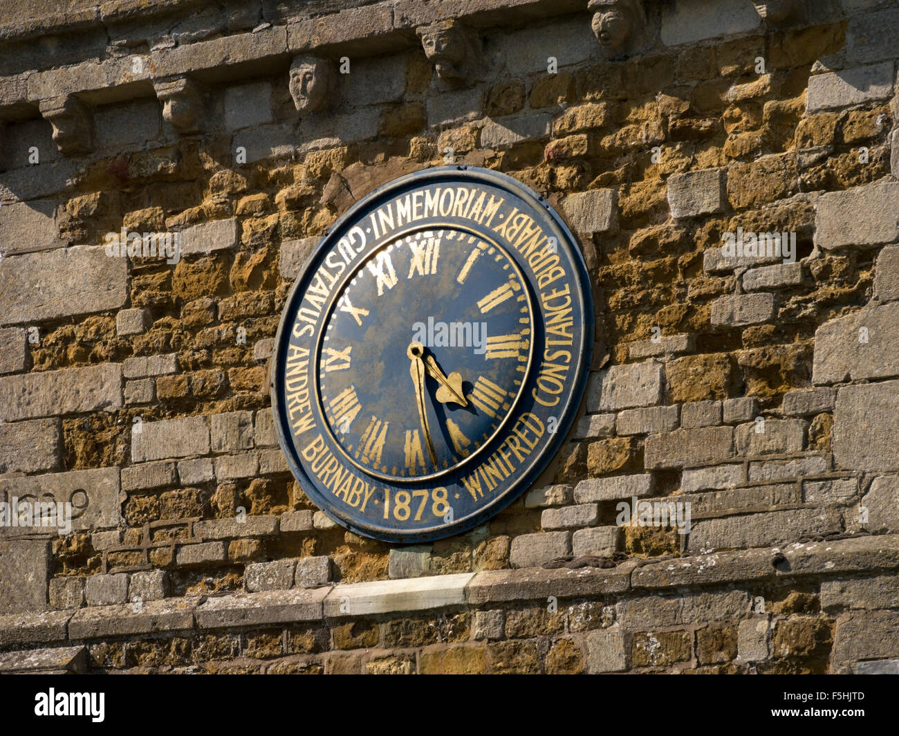 Old church clock face with gold Roman numerals and memorial inscription ...